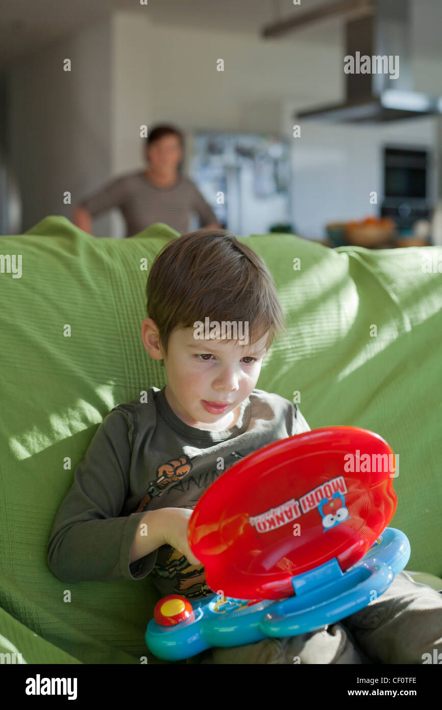 Boy plays with toy laptop Stock Photo - Alamy