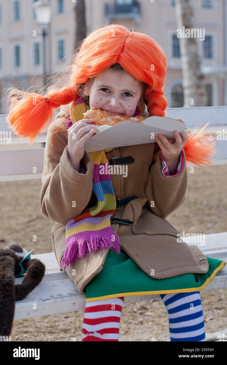 Little girl dressed like Pippi Long stocking eating pizza Stock Photo ...