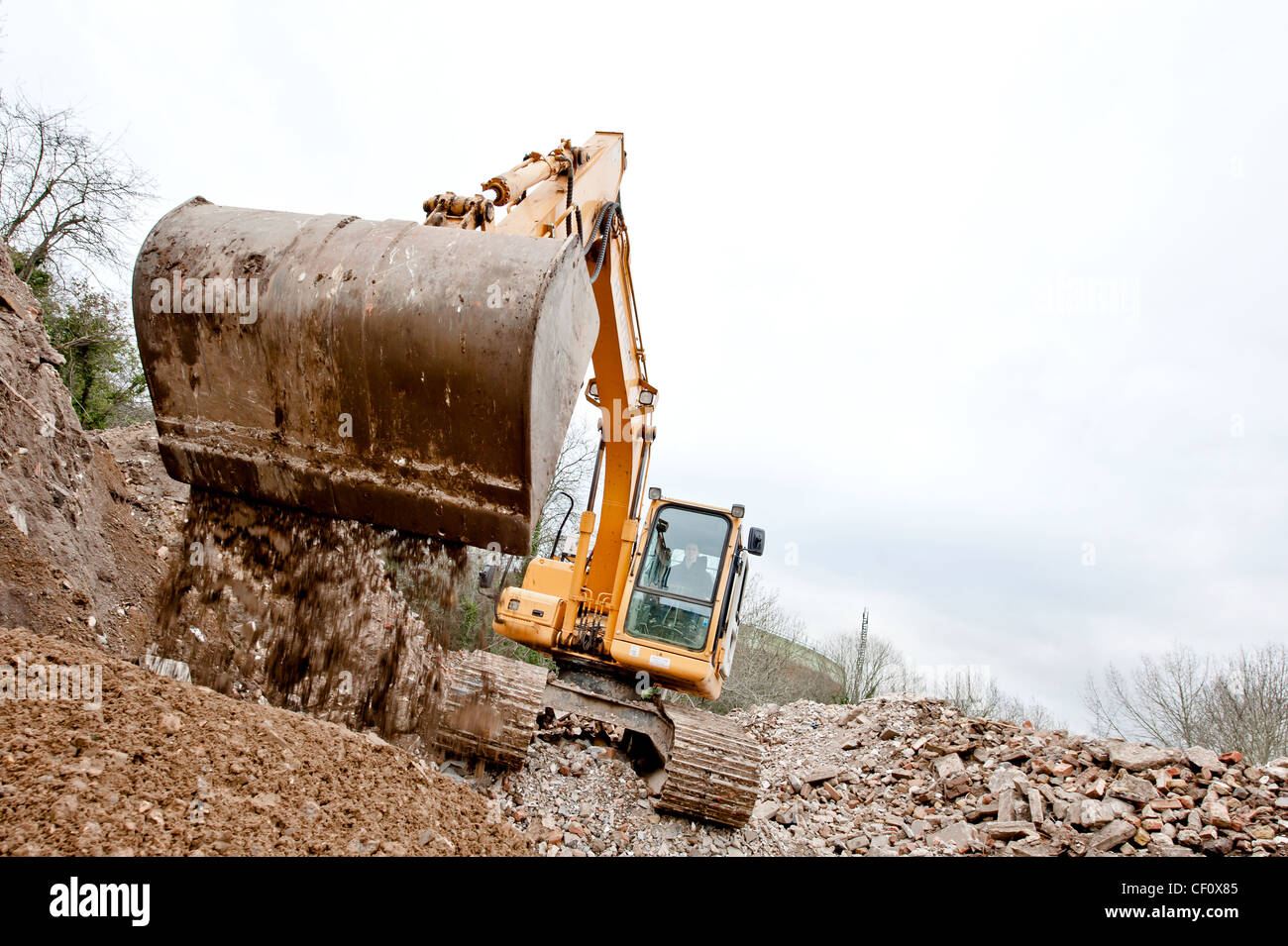 Digger dropping load of dirt on building site Stock Photo - Alamy