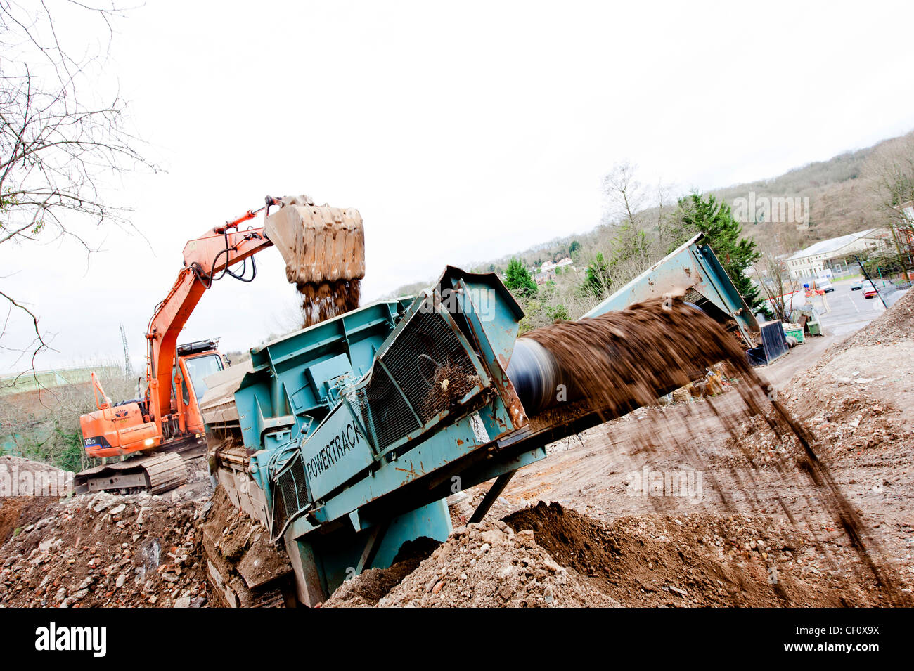 Digger loading rubble onto recycling conveyor belt Stock Photo - Alamy