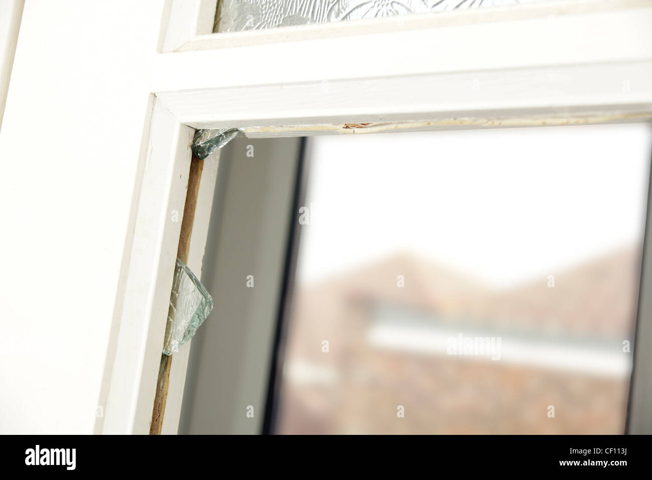 Broken window pane in a front door with shattered & shards of glass ...