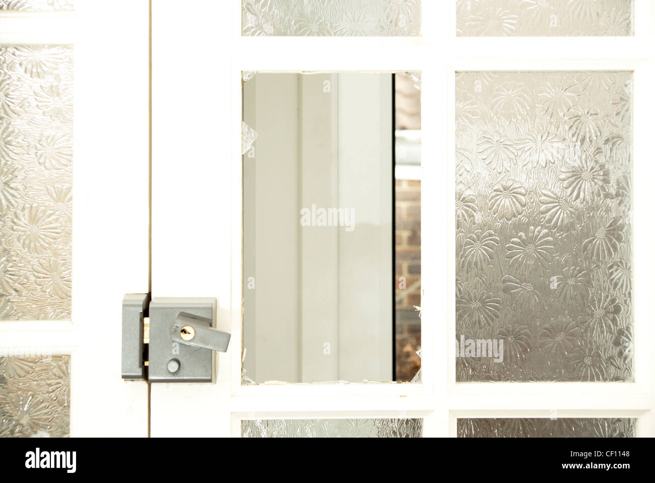 Broken window pane in a front door with shattered & shards of glass ...