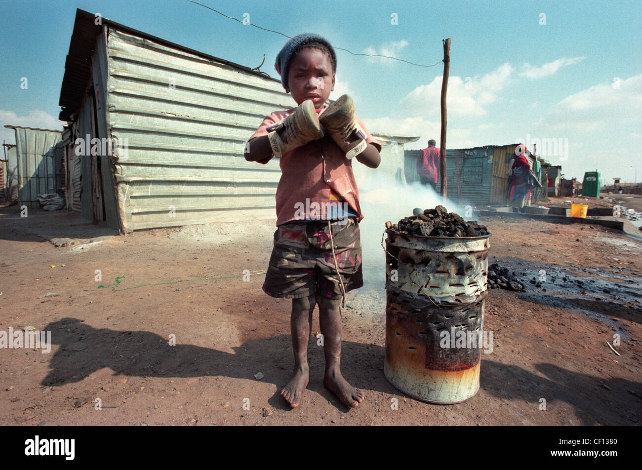Barefoot Township kid in Soweto, South Africa uses shoes to keep his ...