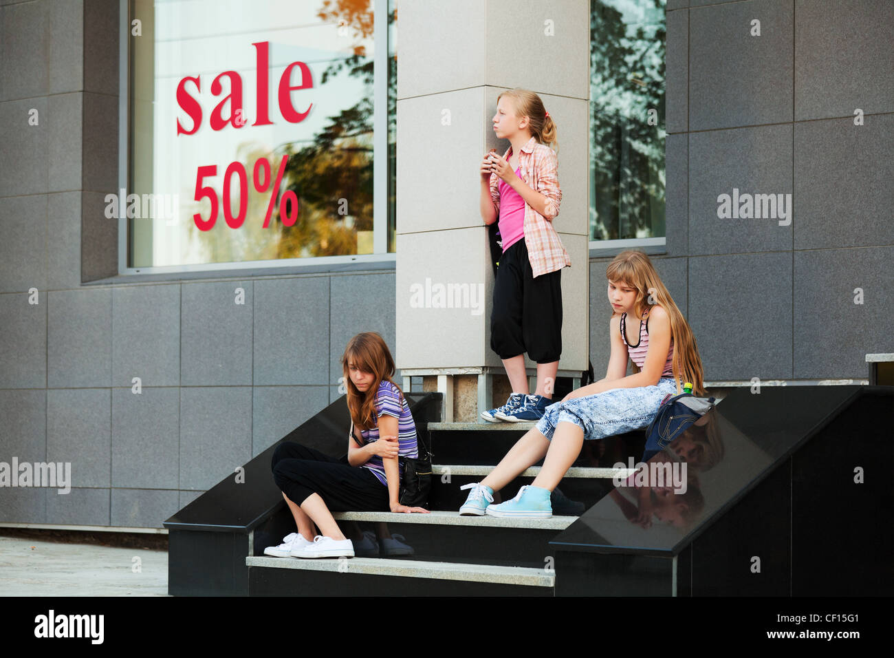 Teenage girls relaxing on a shop steps Stock Photo - Alamy