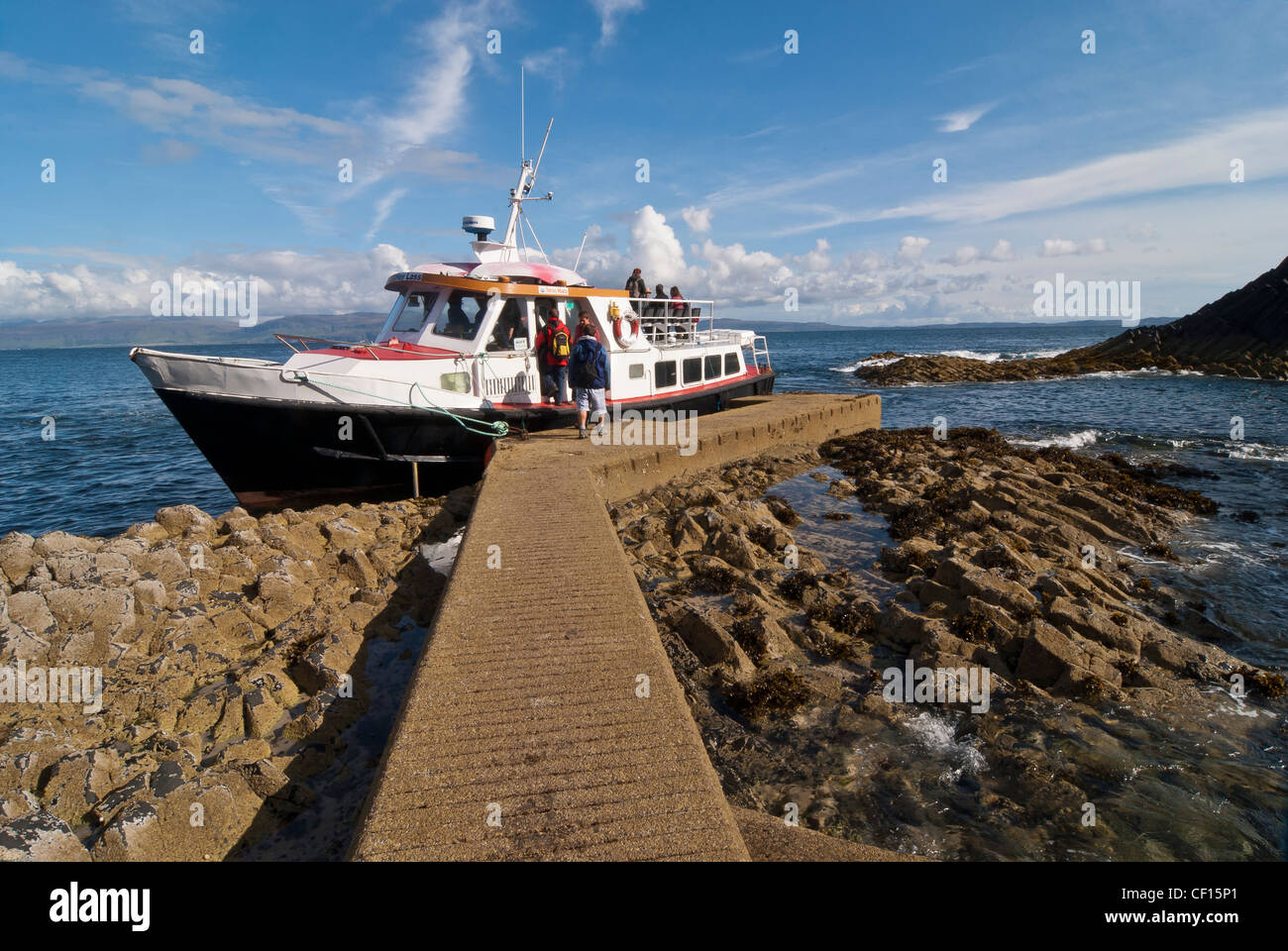 A boat docked against the jetty on the isle of staffa in the inner ...