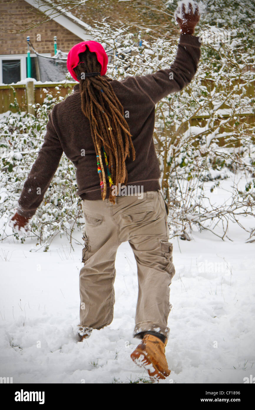 Young Caucasian man with dreadlocks throwing a snowball Stock Photo - Alamy