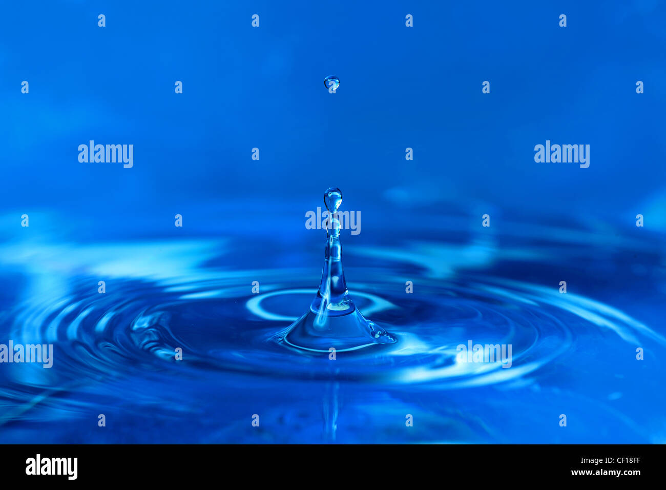 Water drops falling on surface creating ripples Stock Photo - Alamy