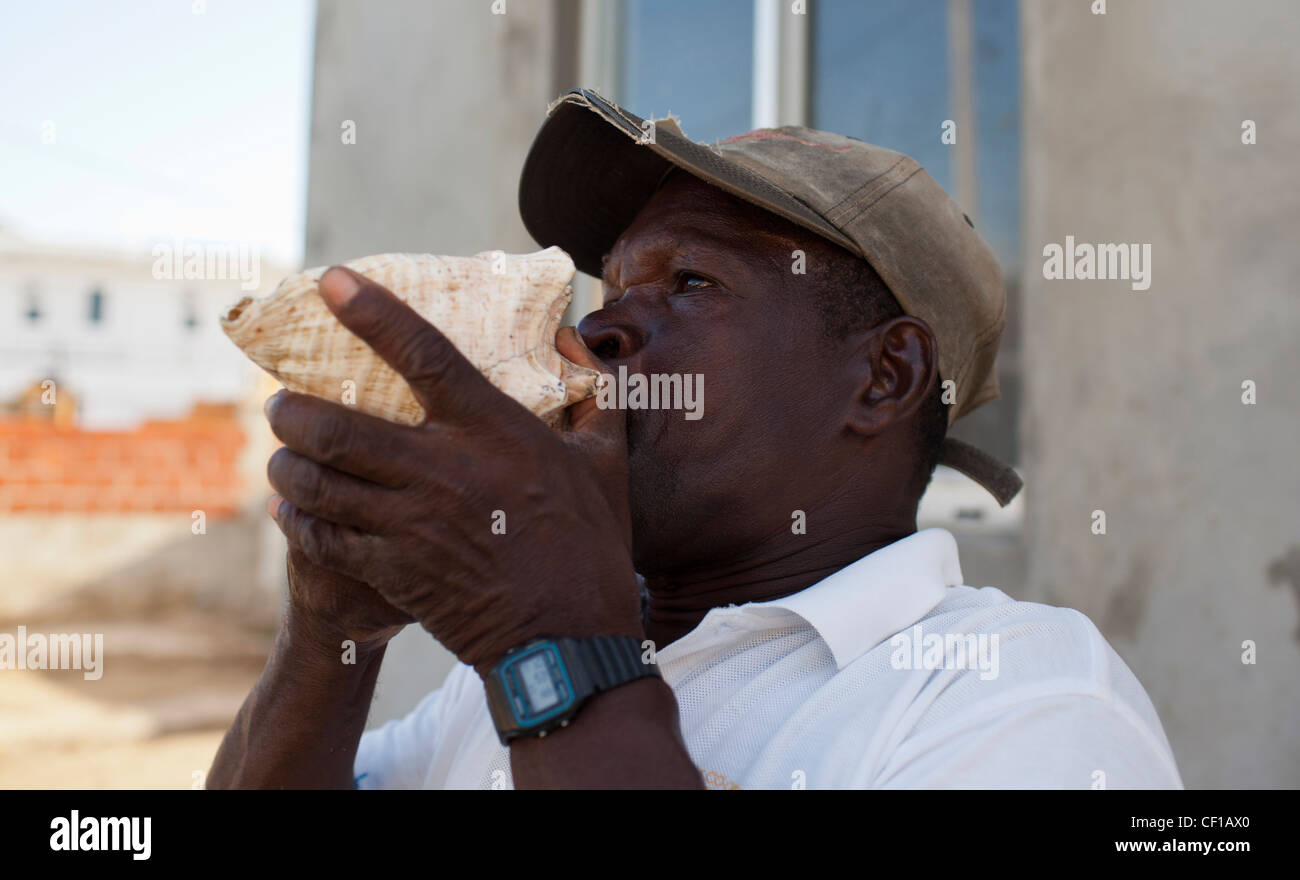A fisherman blows through a conch shell to announce his catch of fresh ...