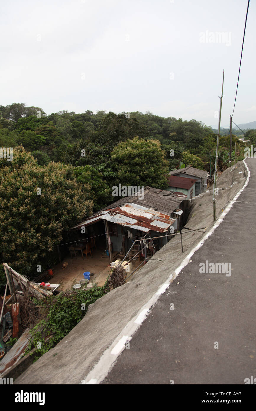 Slum Houses in a village near the road and the forest. Poor people ...