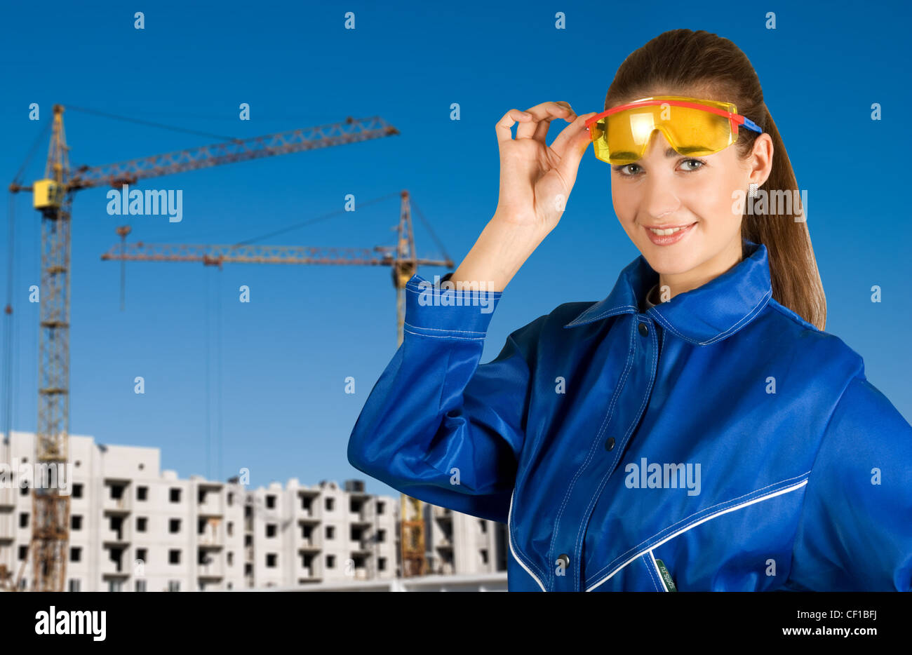 Builder pretty girl at safety glasses on a building background Stock ...