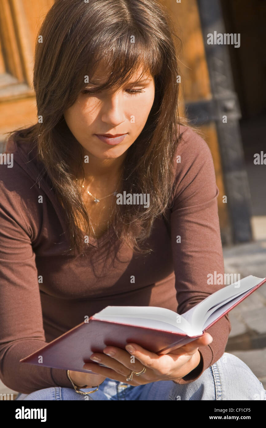 Image of a girl student reading something from a notebook Stock Photo ...