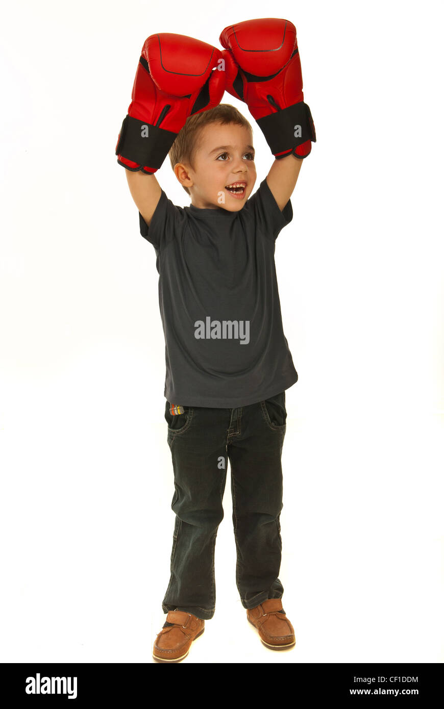 Happy winner boxer kid raising arms in boxing gloves and looking away ...