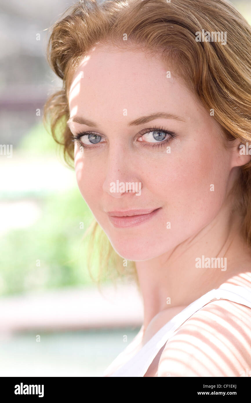 Female with fair wavy hair, wearing subtle make up, smiling, looking at ...