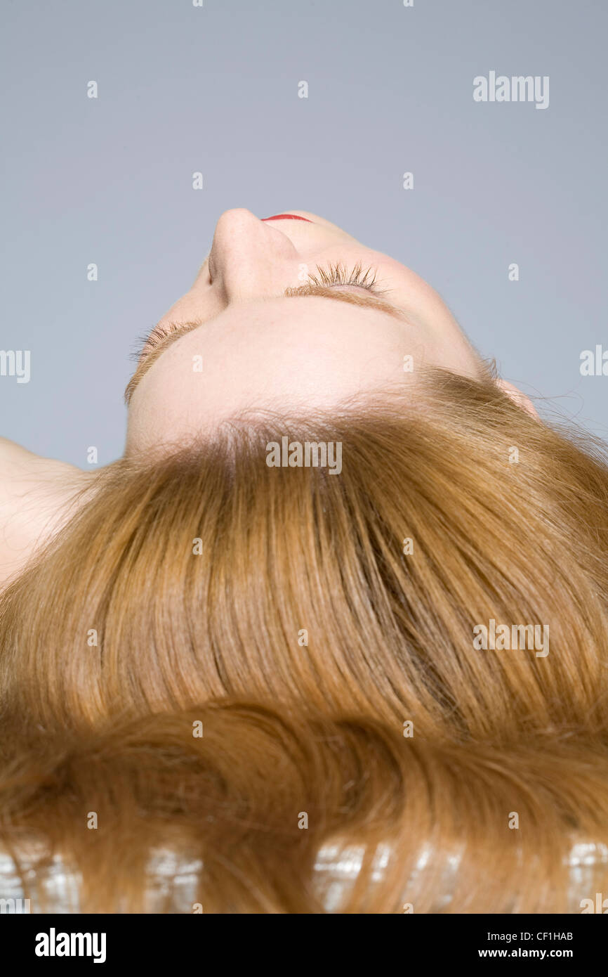 Close up of female's face, chin up, shot from above, unsmiling, looking ...
