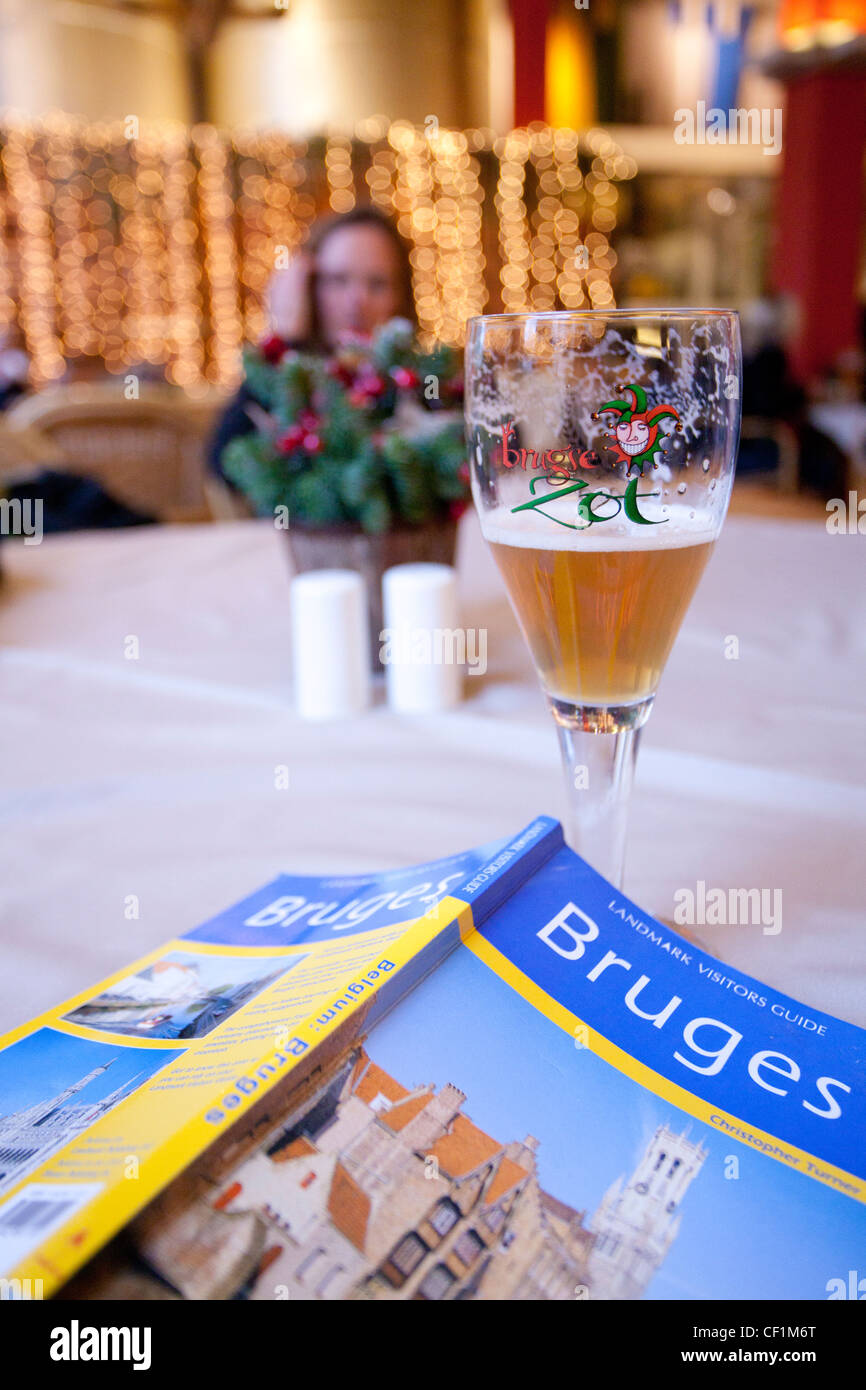 A table top in a bar with a Belgian beer and a guide book of Bruges ...