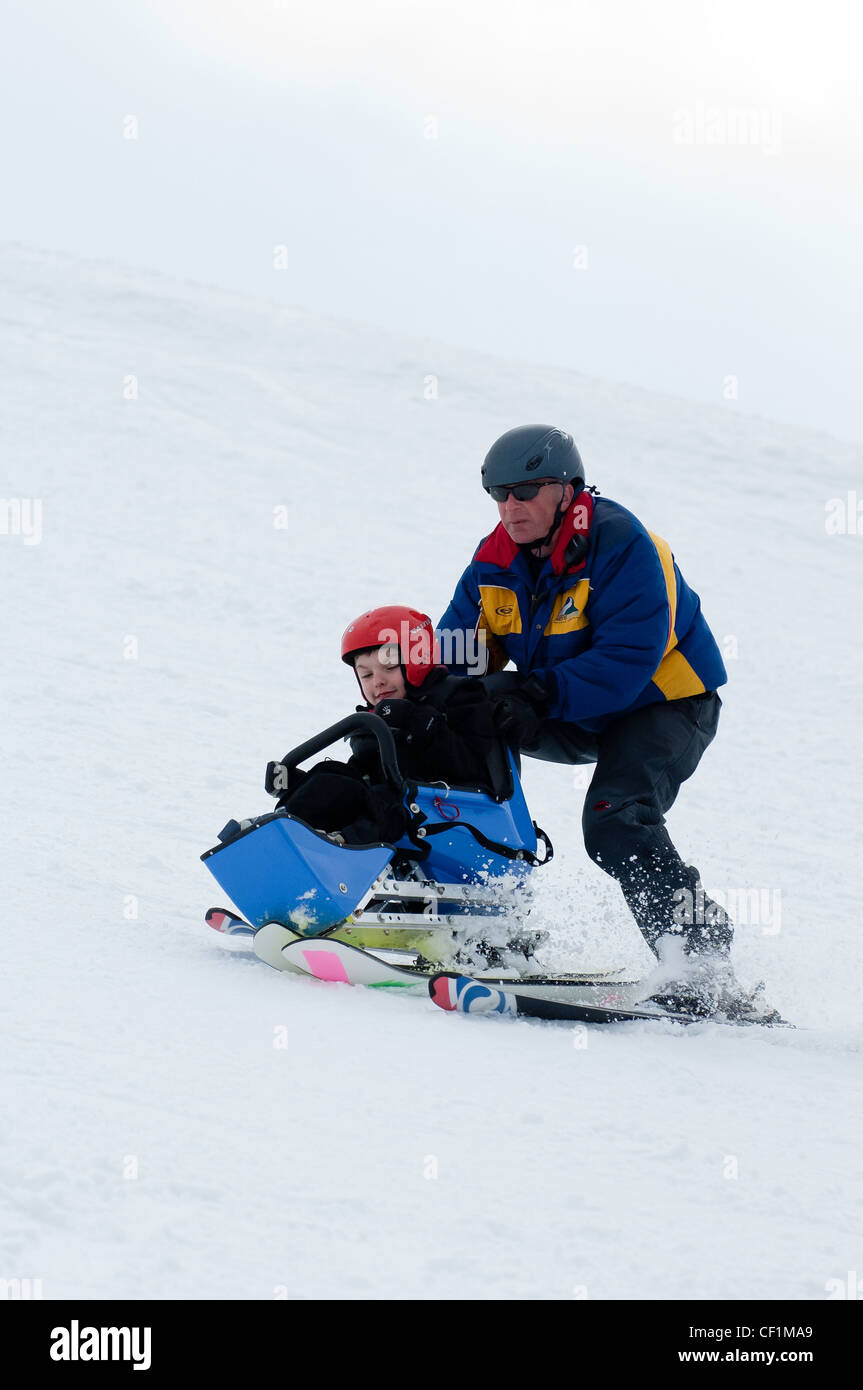 Disabled boy in special adapted sledge enjoys the ride Stock Photo - Alamy