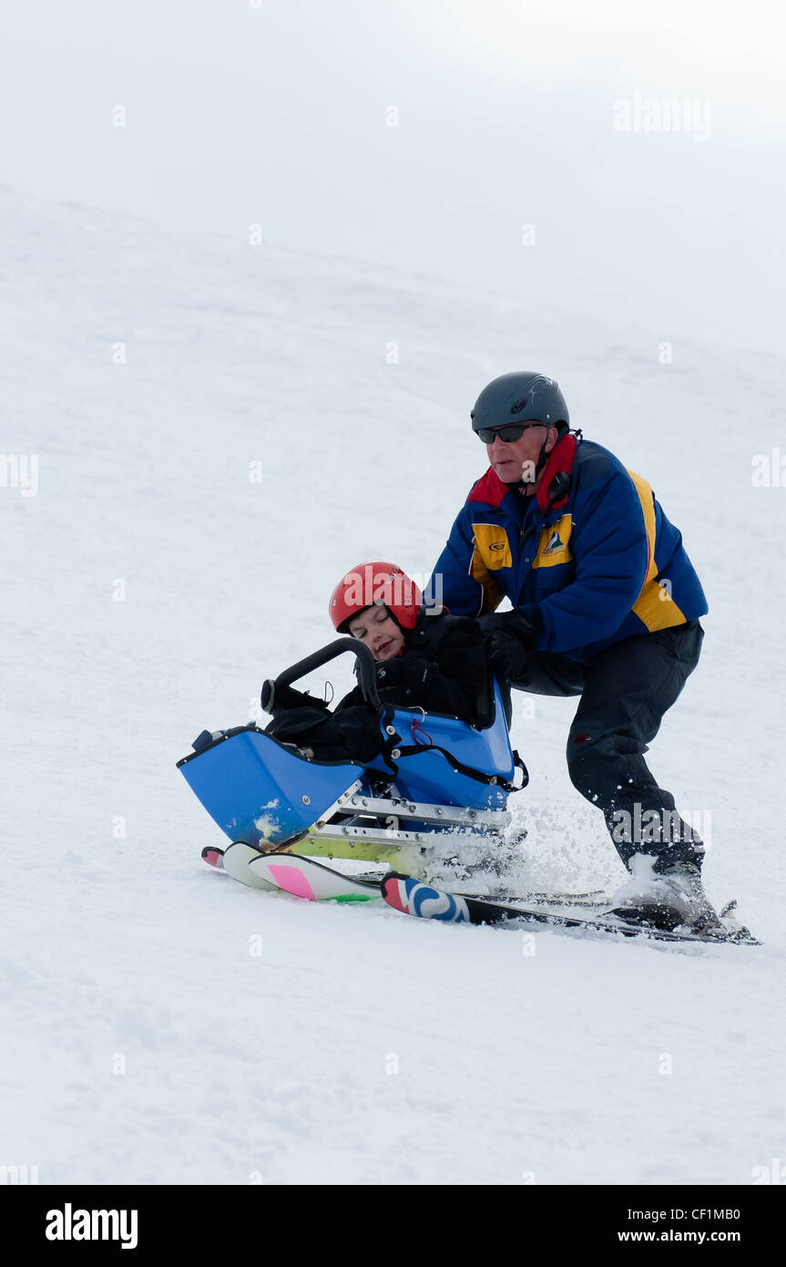 Disabled boy in special adapted sledge enjoys the ride Stock Photo - Alamy