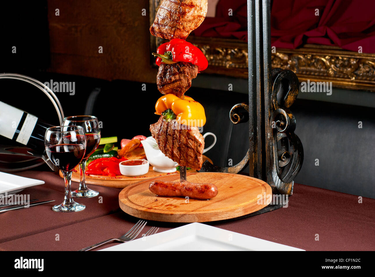 Big tasty roasted meat cuts at skewer on a decorated table Stock Photo ...