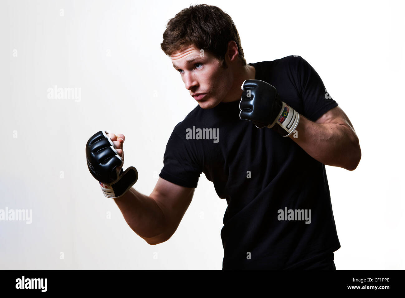 A man inside a studio in a martial arts fight wearing boxing gloves ...