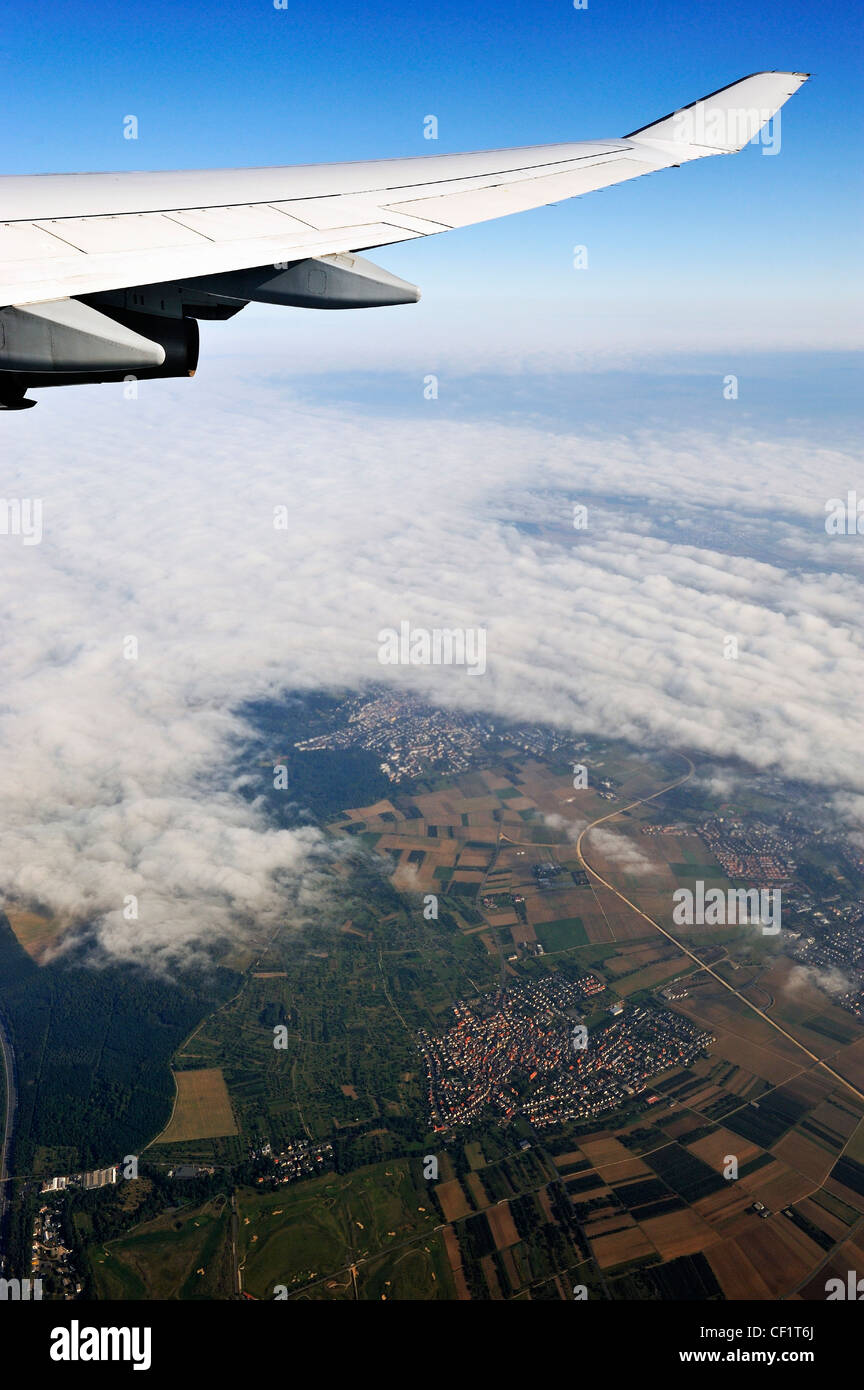 Wing of flying airplane over german villages surrounding Frankfurt ...