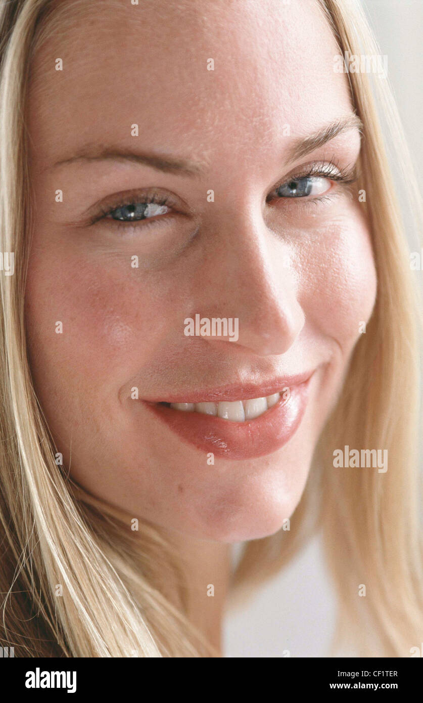 Cropped female with long fair hair wearing white vest top subtle make ...