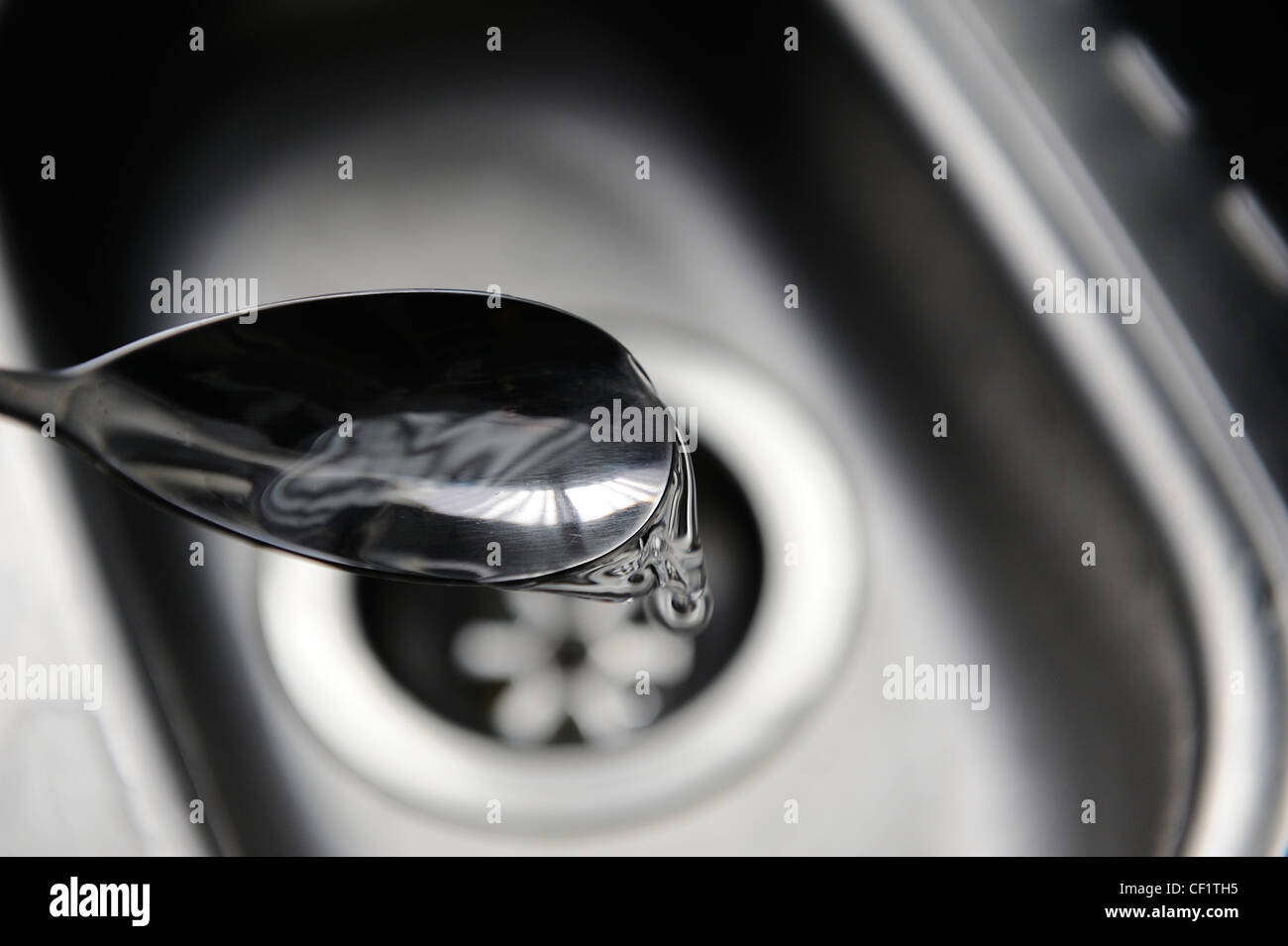 water falling from a spoon into a sink england uk Stock Photo - Alamy