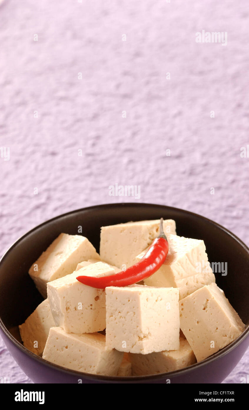 Cubed tofu in black bowl with whole red chilli Stock Photo - Alamy