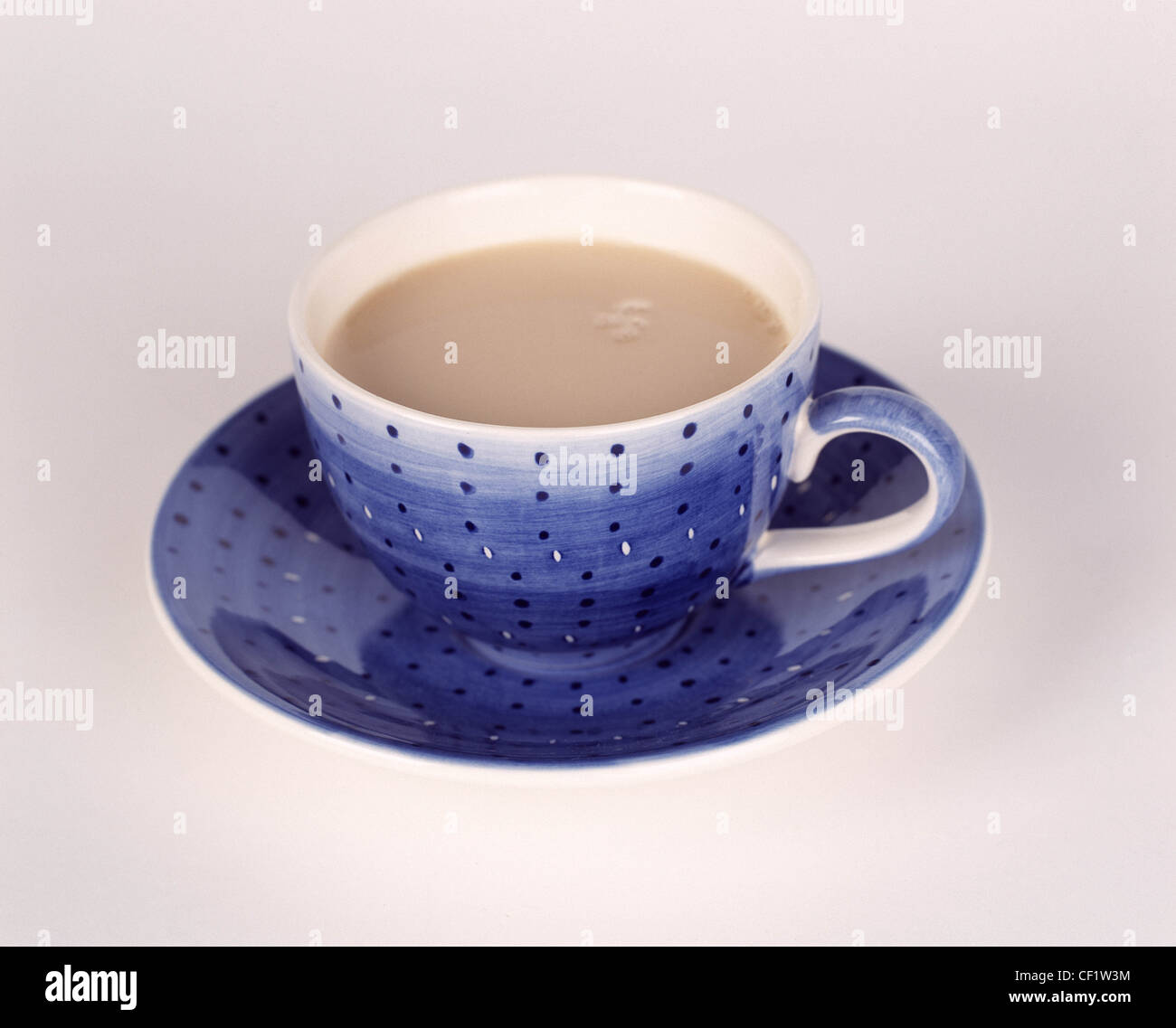 Blue and navy spotted cup and saucer containing tea Stock Photo - Alamy