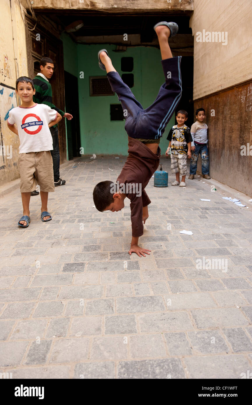 Kid doing a hand stand in the streets of the Medina in Fez, Morocco ...