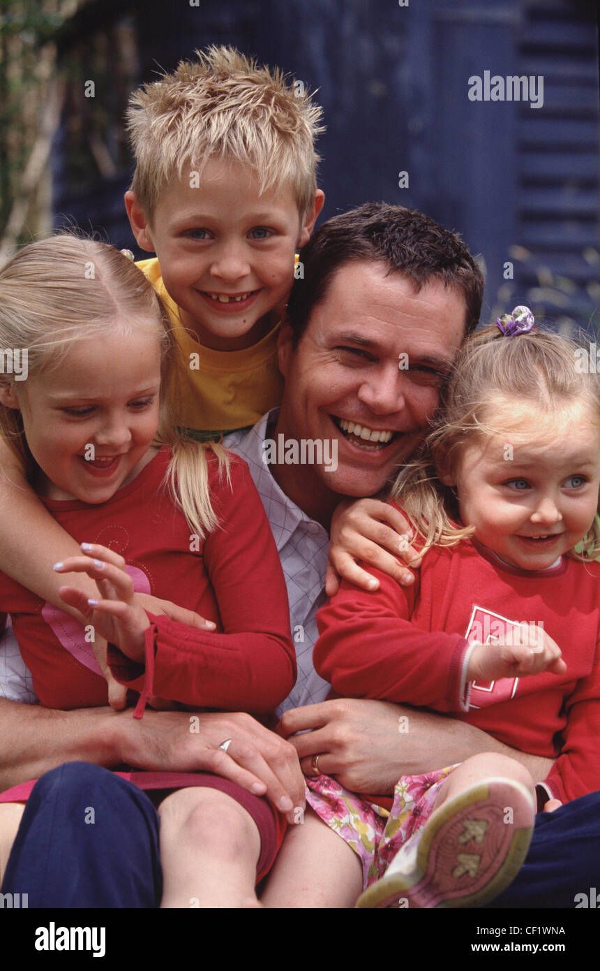 Father short brown hair male child spiky blonde hair standing behind ...