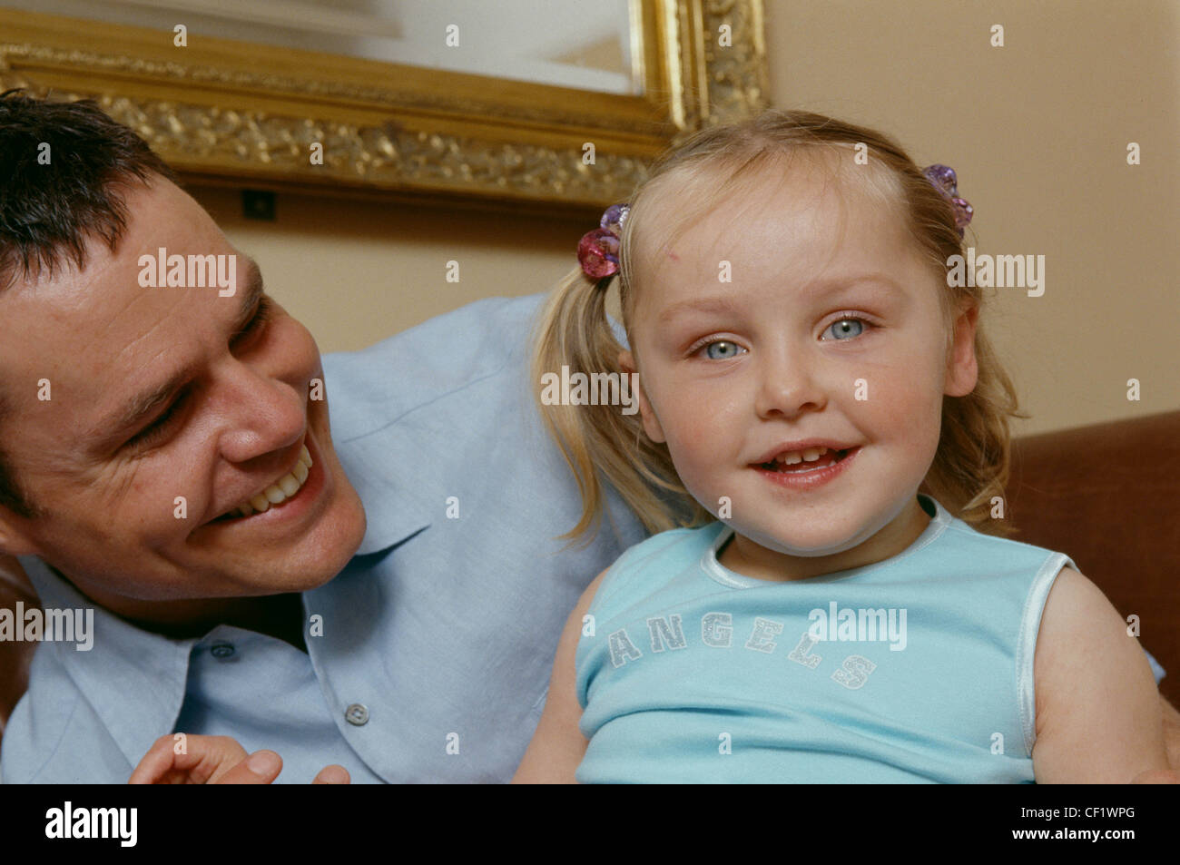 Father short brown hair wearing short sleeved blue shirt sitting on ...