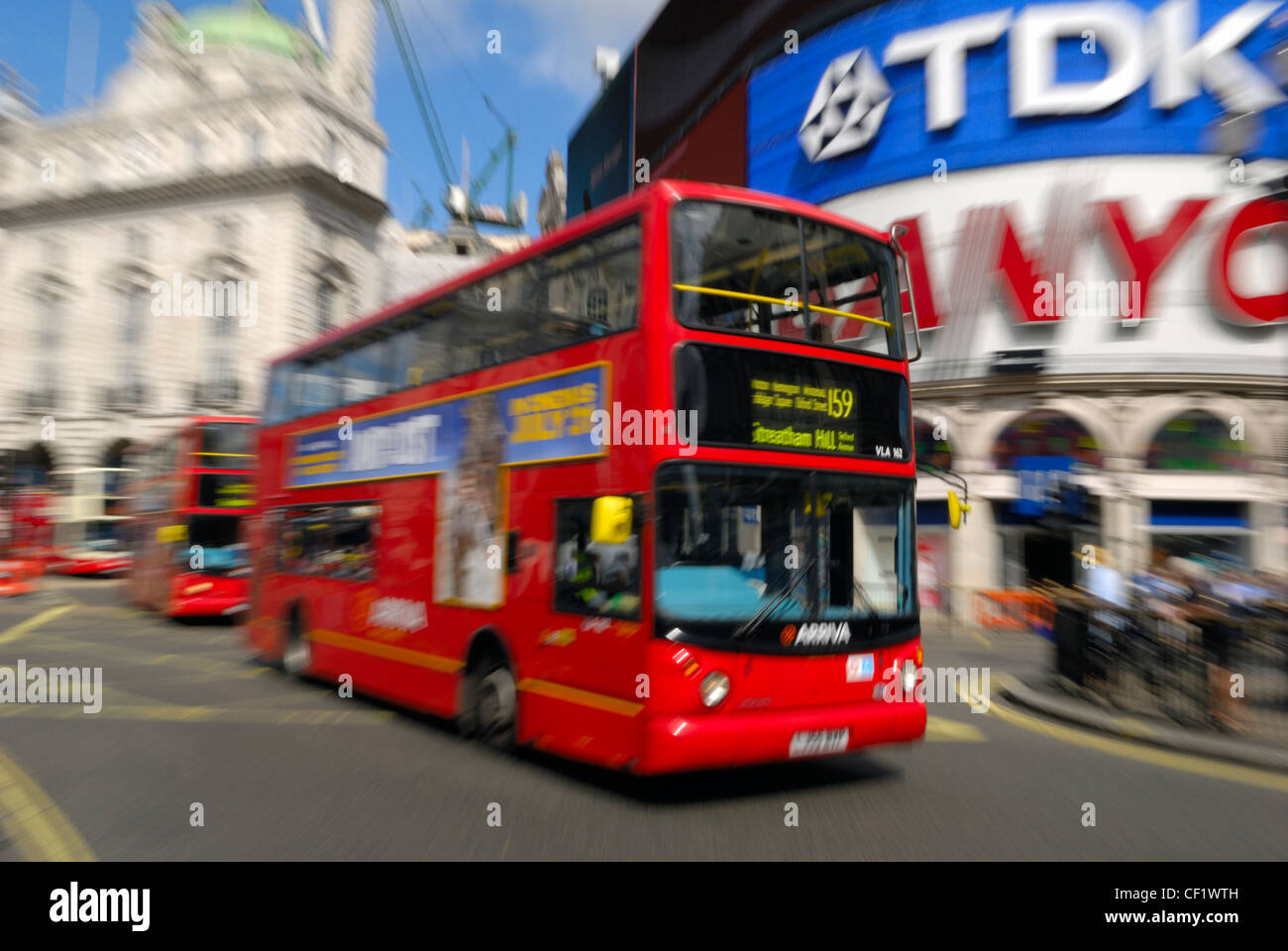 London buses passing the large iconic advertising signs in Piccadilly ...