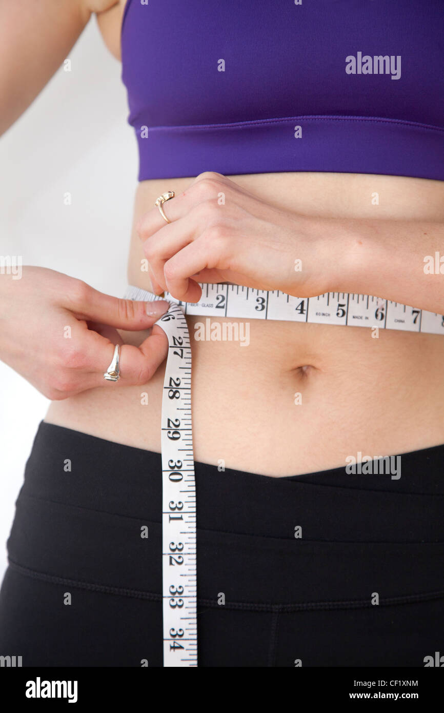 Woman measuring waistline Stock Photo - Alamy