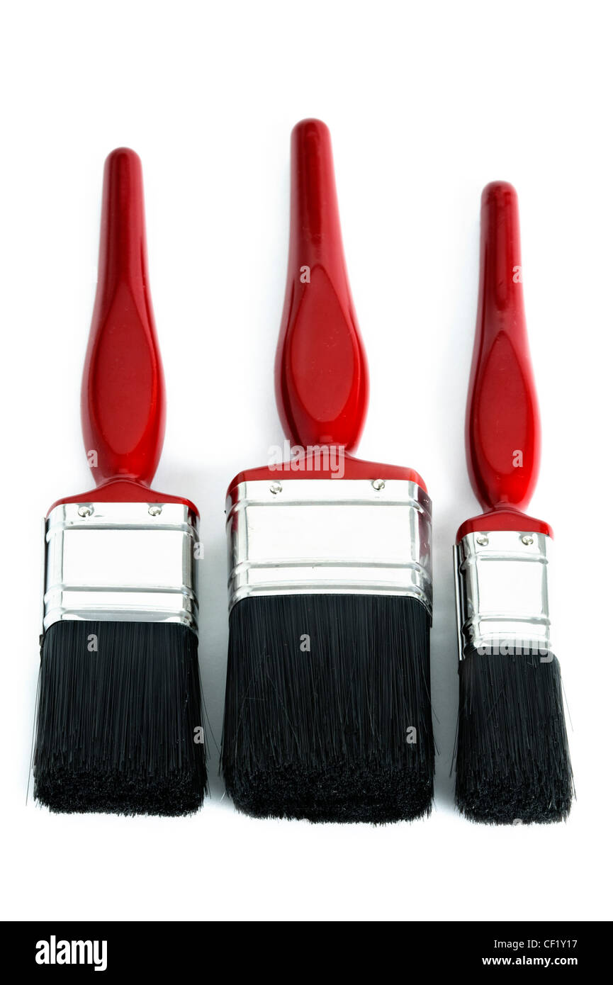 three red paintbrushes of different sizes isolated on a white ...