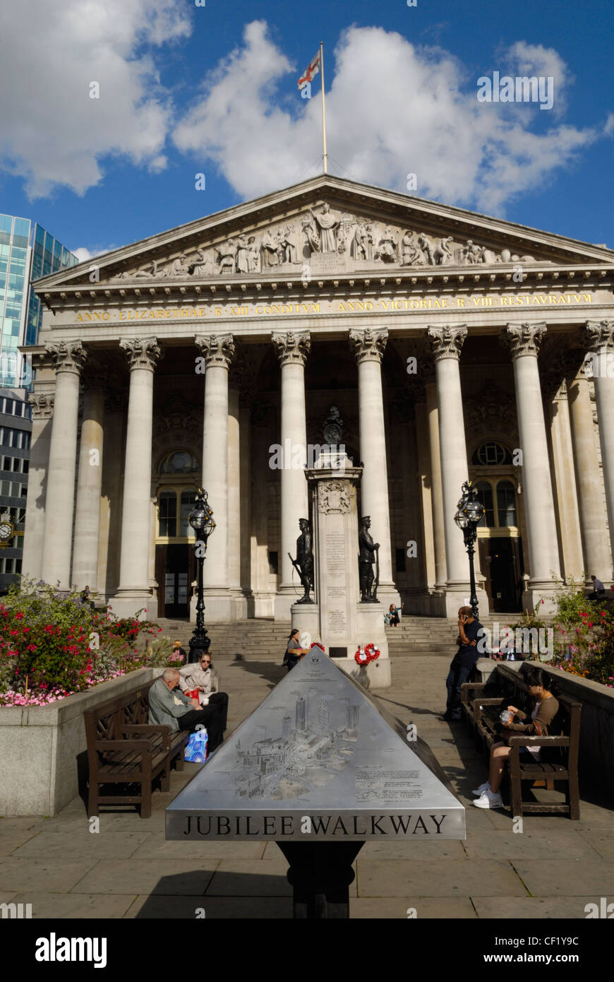 People sitting on benches outside the Royal Exchange building ...