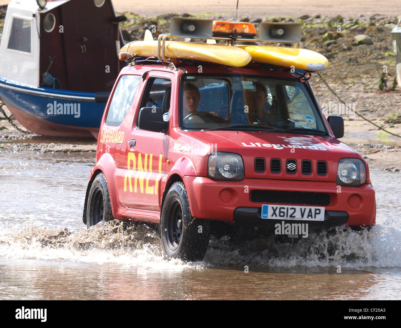 Lifeguards in a Suzuki jeep driving through water, Bude, Cornwall, UK ...