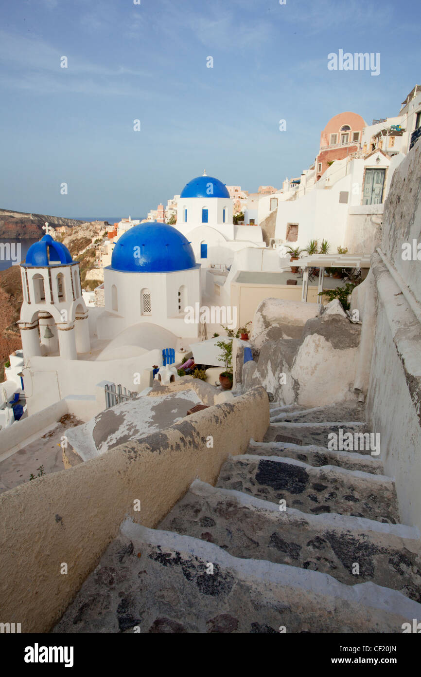 A view down a small winding path towards a set of blue domed Greek ...