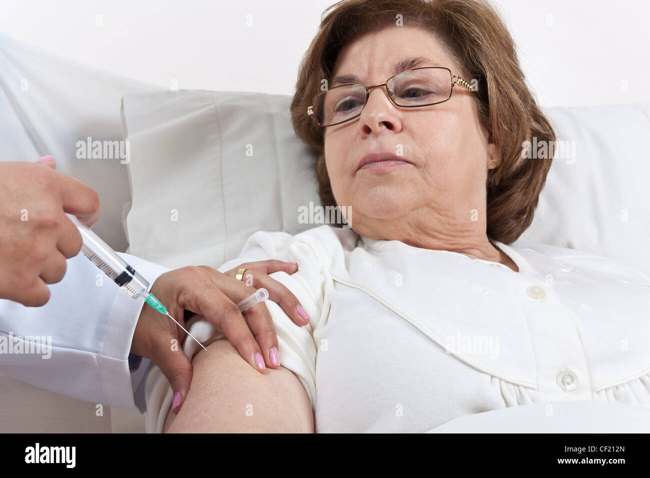 Doctor giving an injection onto a Senior Patient Arm Stock Photo - Alamy