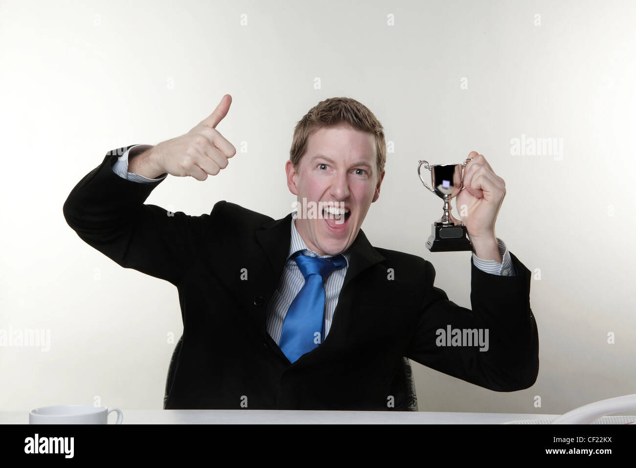 businessman holding up a cup medal to show that hes a winner Stock ...