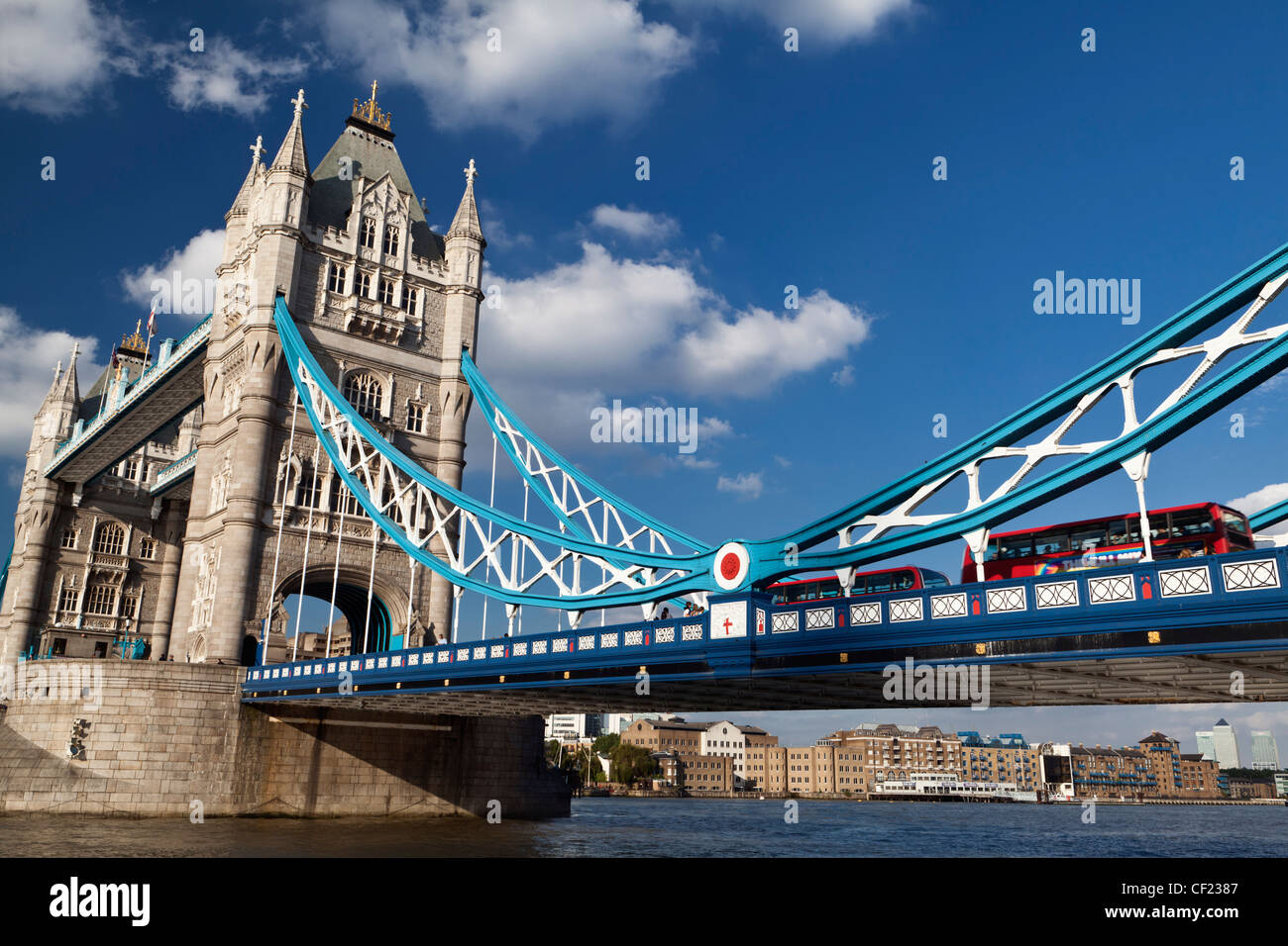 Red London buses crossing the River Thames over Tower Bridge, one of ...