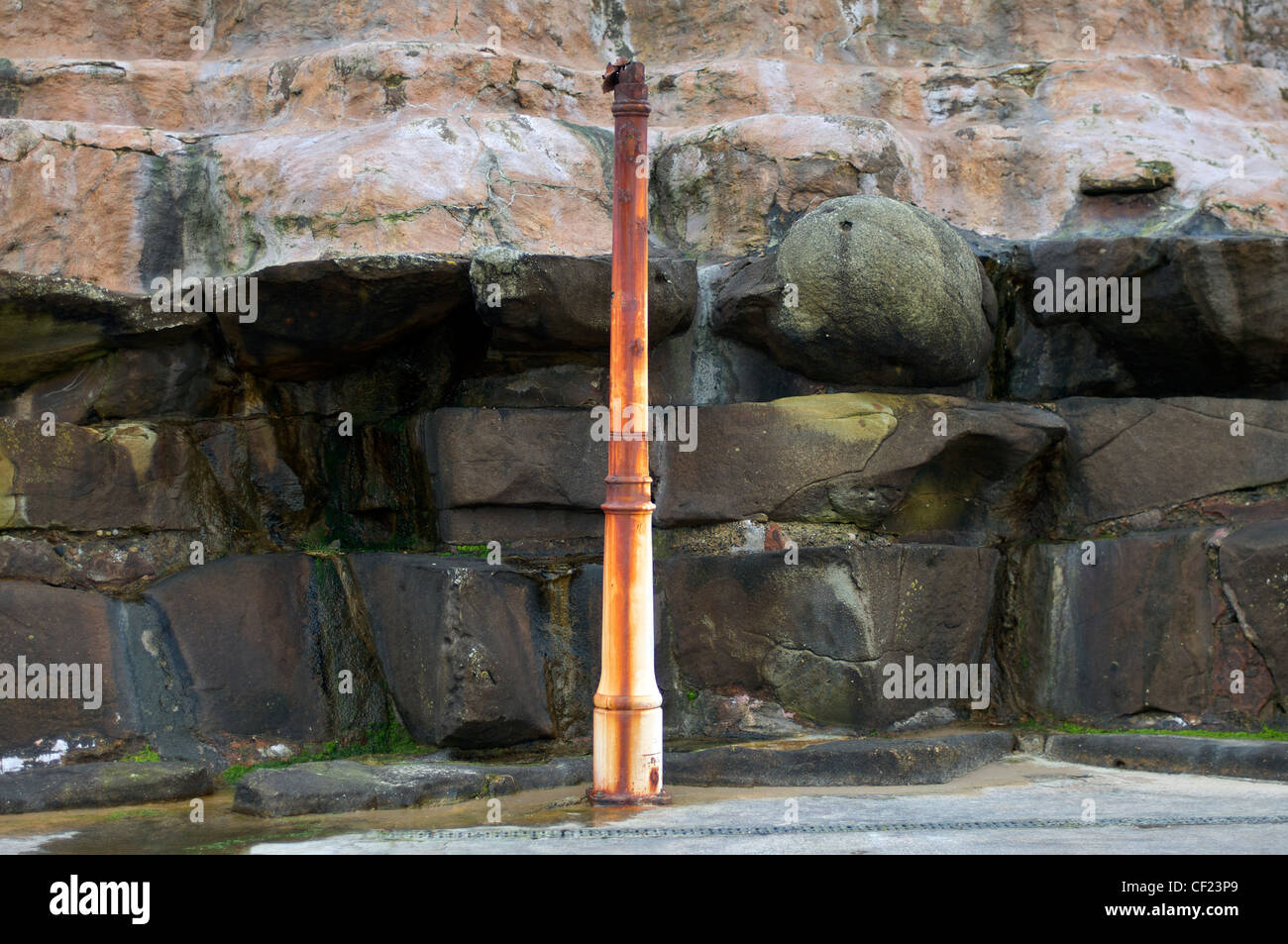 Rusty post against cliff face Stock Photo - Alamy