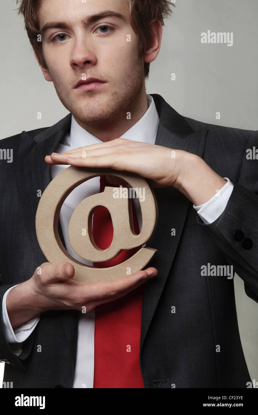 businessman holding the at sign for email Stock Photo - Alamy