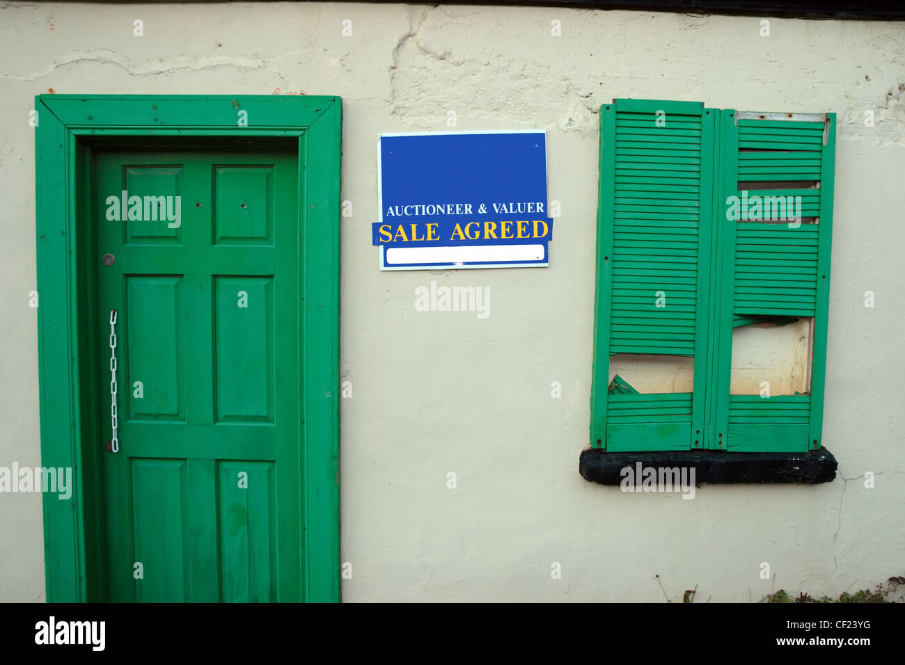 a sale agreed sign on a wall with green door and window shutter Stock ...