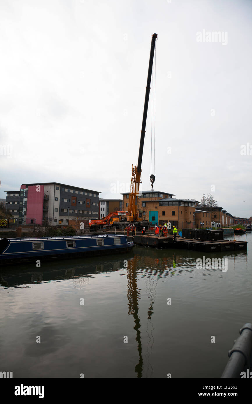 High rise tower crane lifting large floating blocks on river Witham in ...