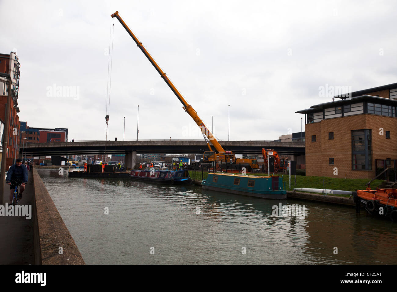 High rise tower crane lifting large floating blocks on river Witham in ...