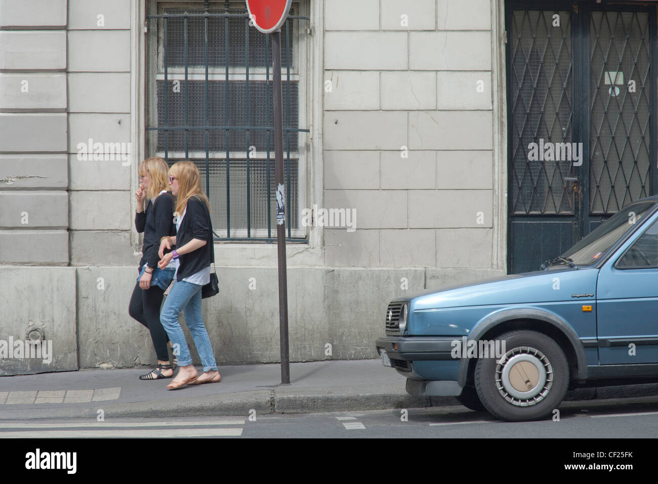 two young ladies walking on a side street in Paris Stock Photo - Alamy