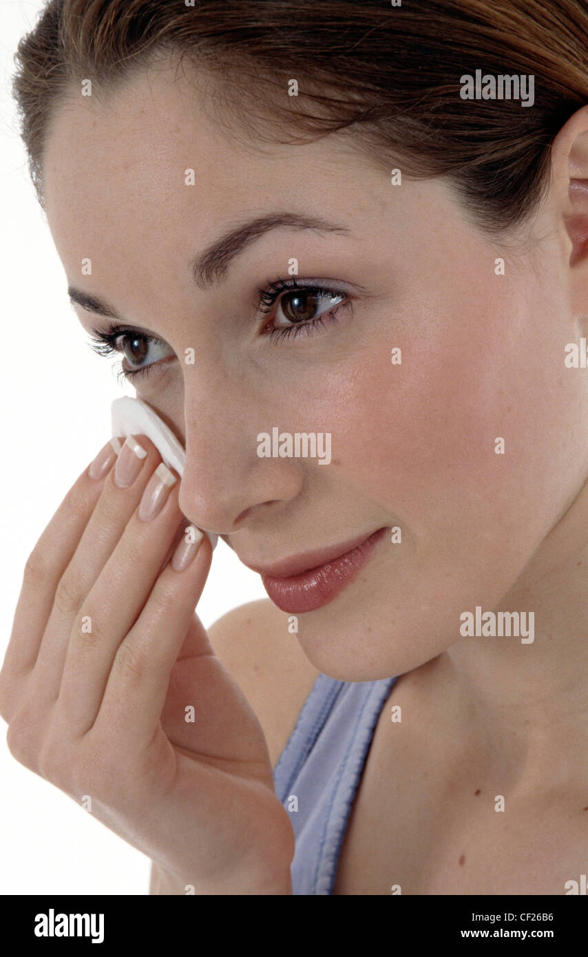 Female wiping cheek with cotton wool pad Stock Photo - Alamy