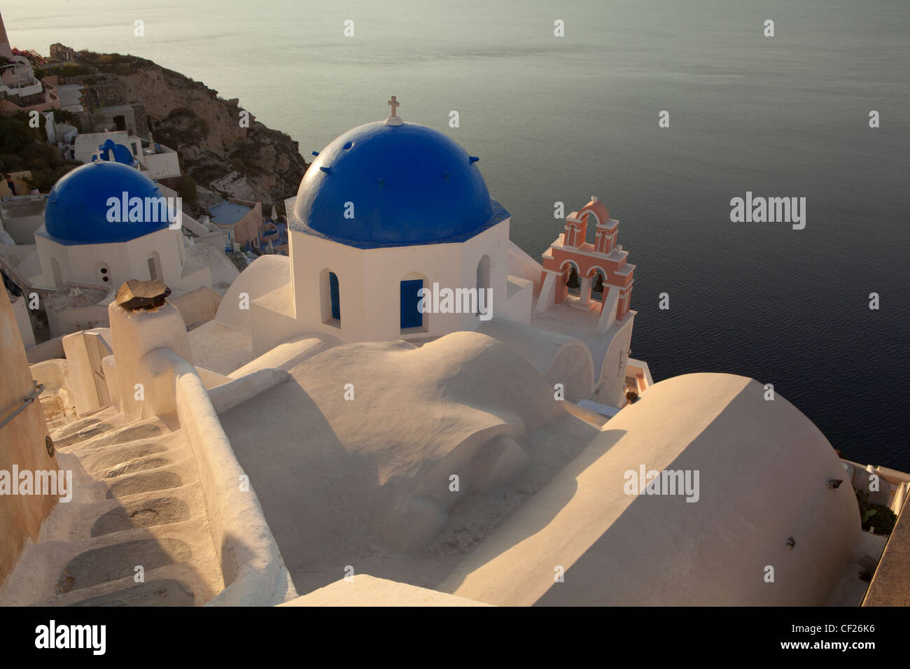 A view of a traditional blue domed church and a pink bell tower with ...
