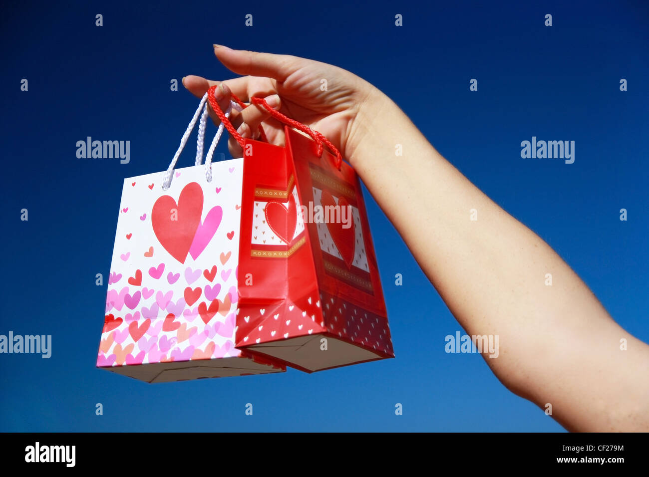 Present in hand on blue sky background Stock Photo - Alamy