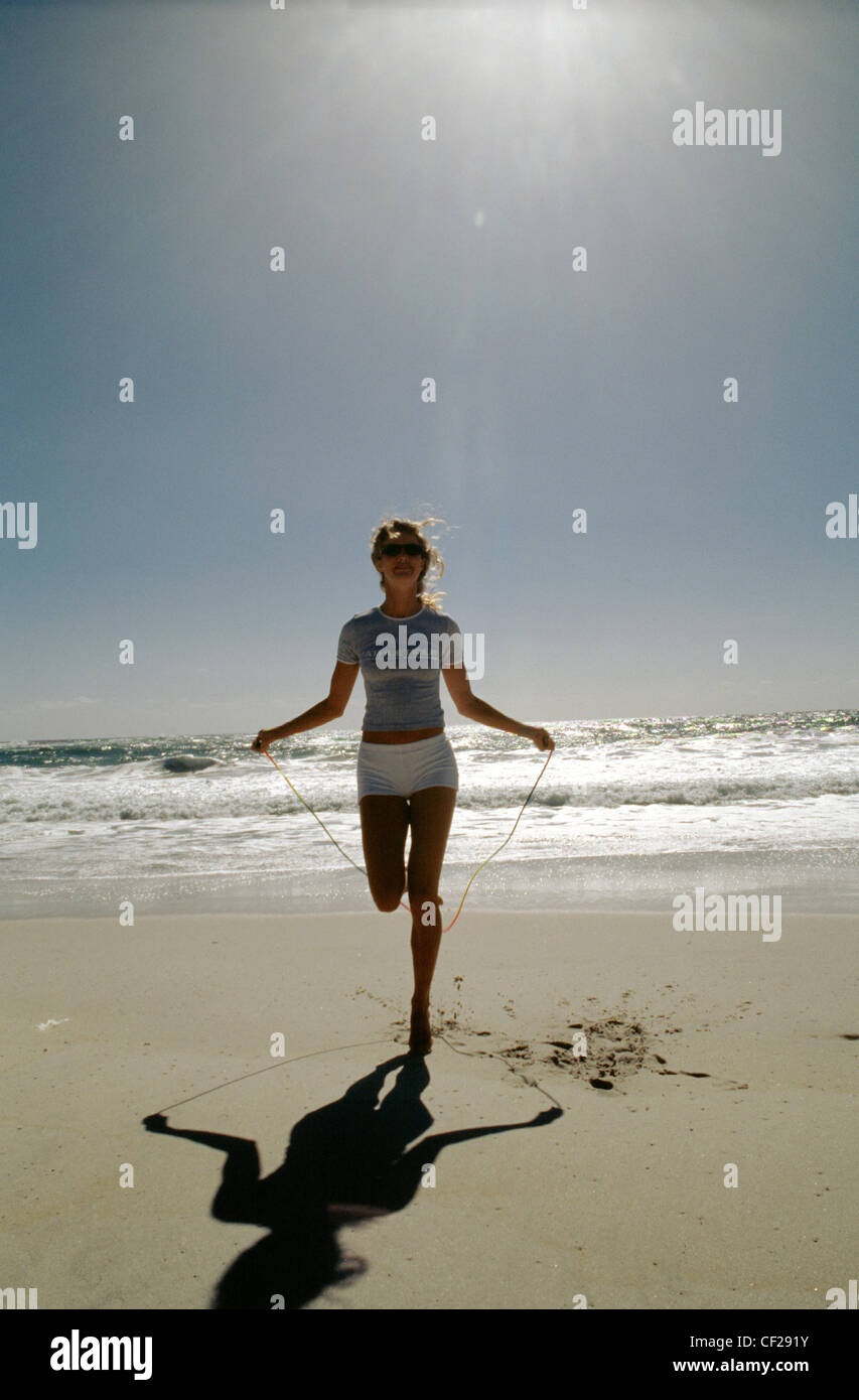 Female skipping on beach Stock Photo - Alamy